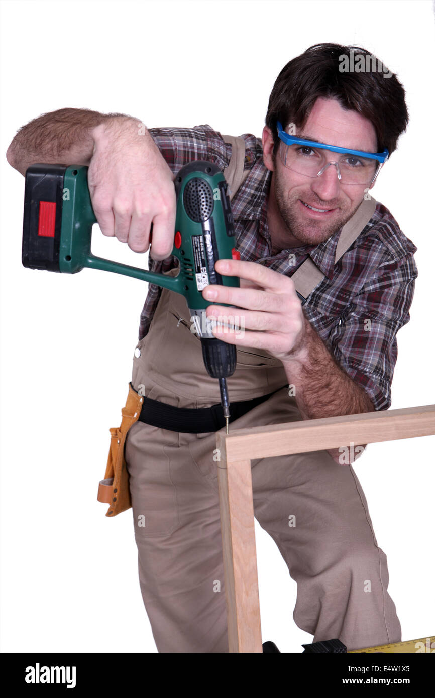 Man drilling into wooden frame Stock Photo - Alamy
