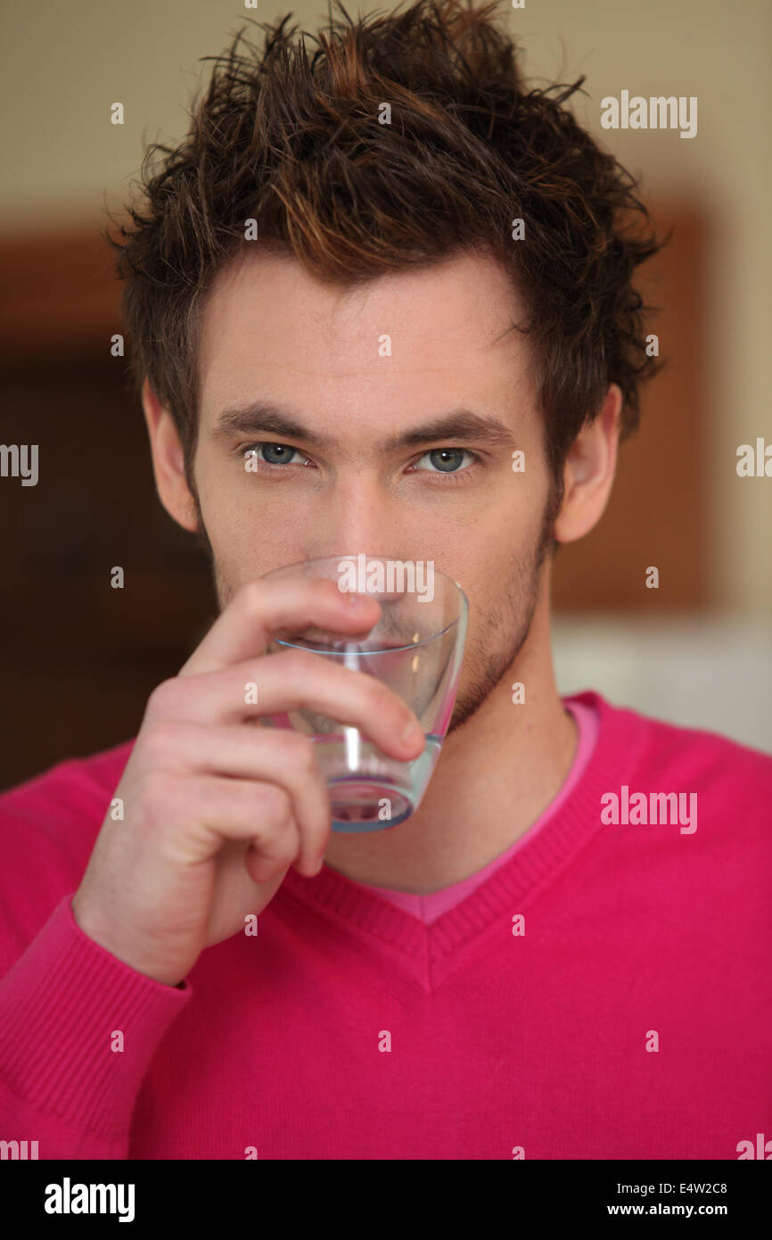 Man casually drinking glass of water Stock Photo - Alamy