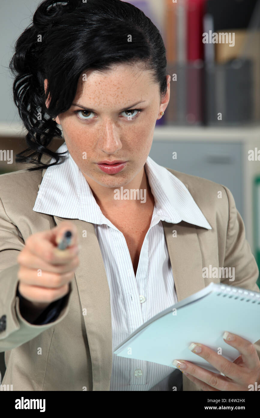 Stern woman pointing pen Stock Photo - Alamy