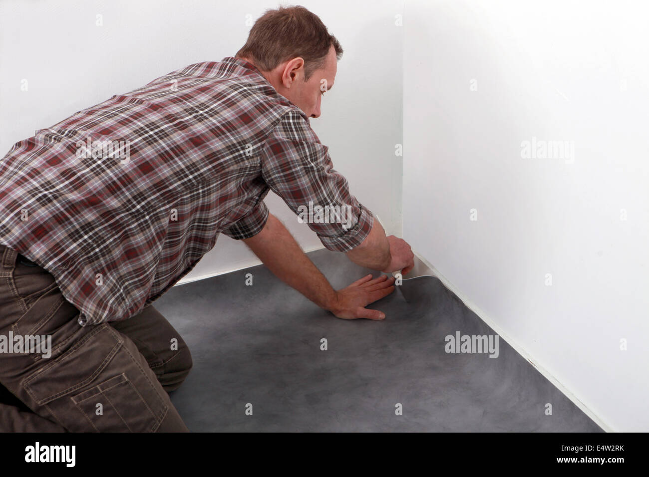 Man laying new carpet in room Stock Photo - Alamy