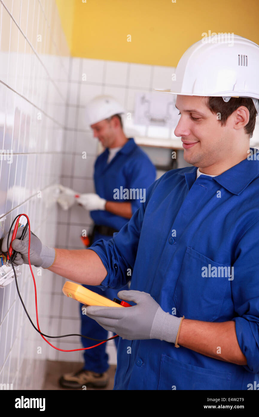 Two men inspecting power supply Stock Photo - Alamy