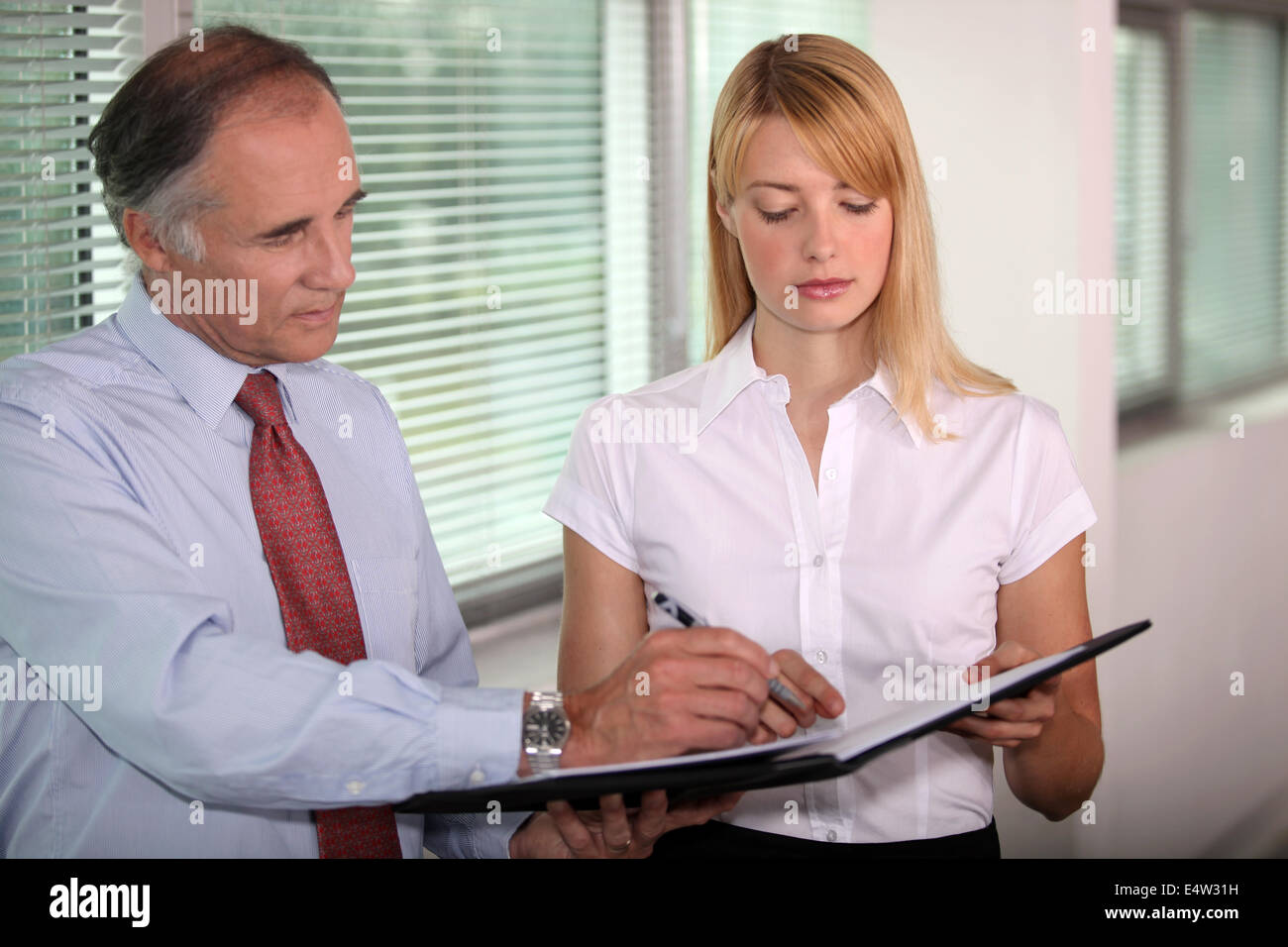Boss signing paperwork Stock Photo - Alamy