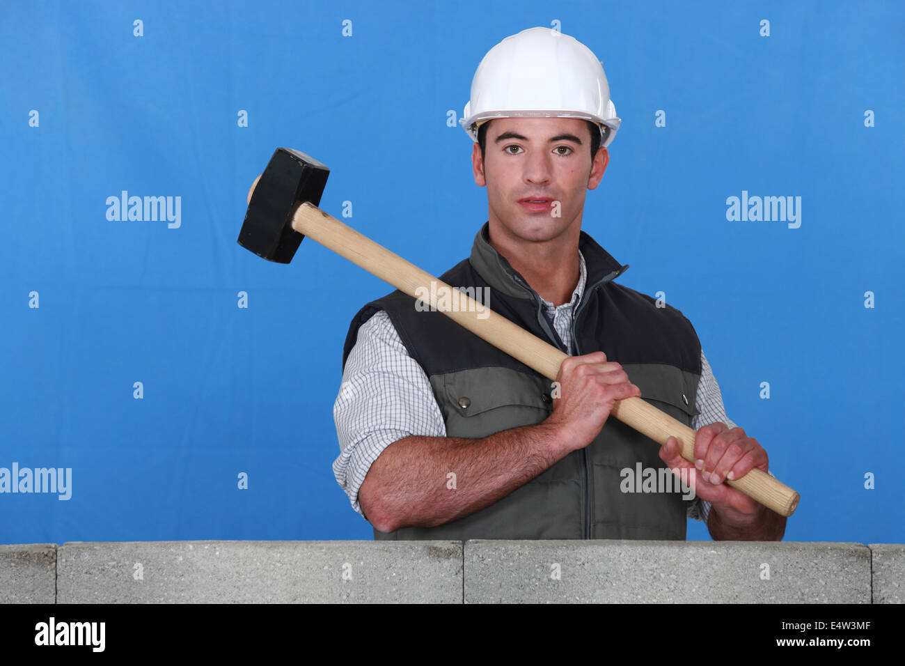 Man lifting hammer next to wall Stock Photo - Alamy
