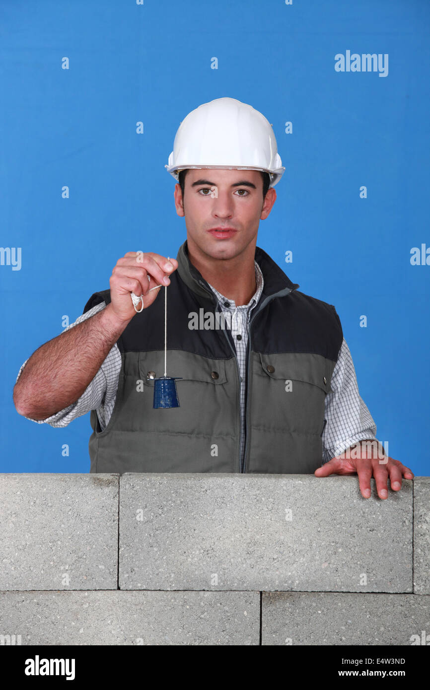Mason using tool to check wall Stock Photo - Alamy