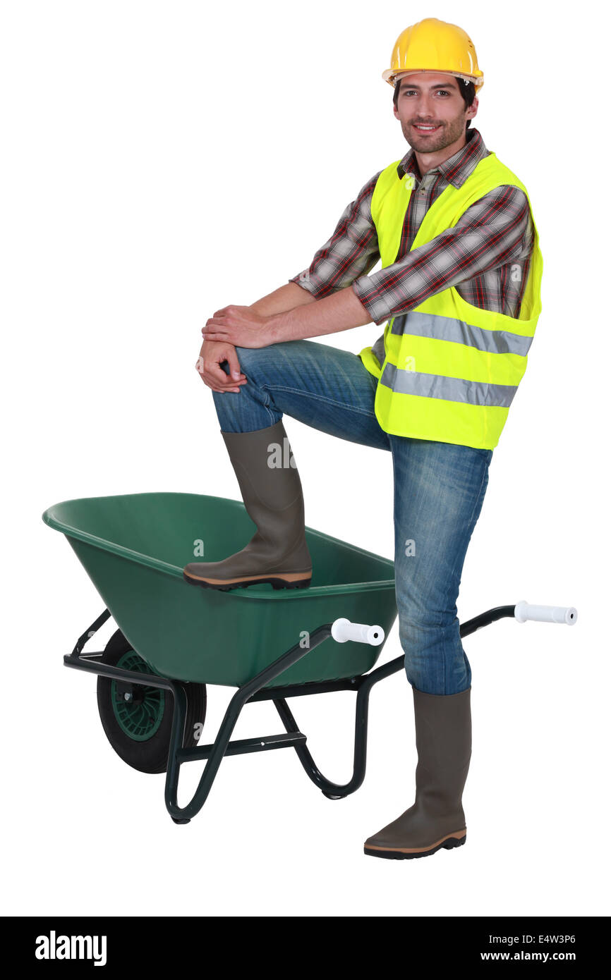 Man stood with one foot on wheelbarrow Stock Photo - Alamy