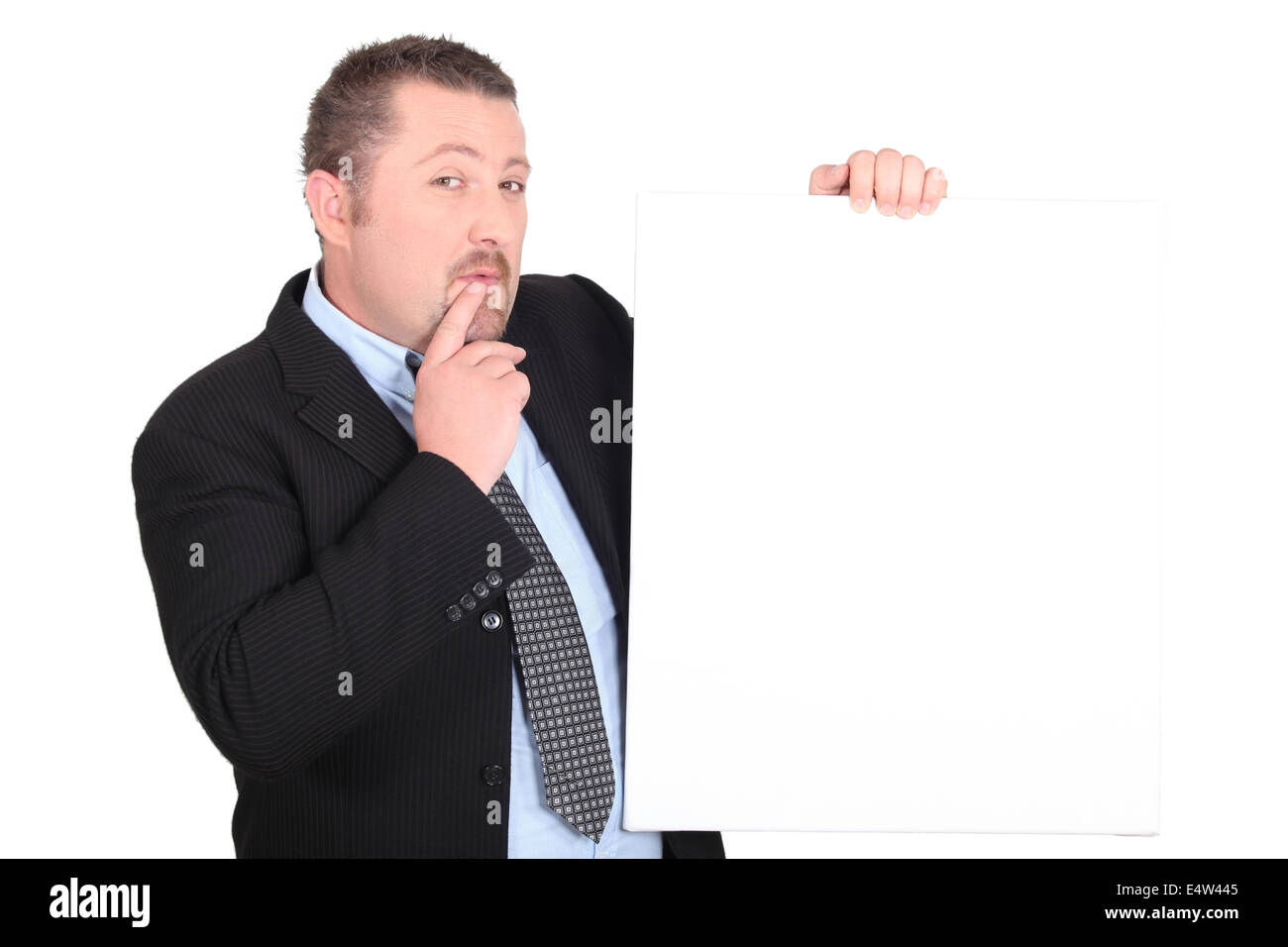 Perplexed man with white sign Stock Photo - Alamy