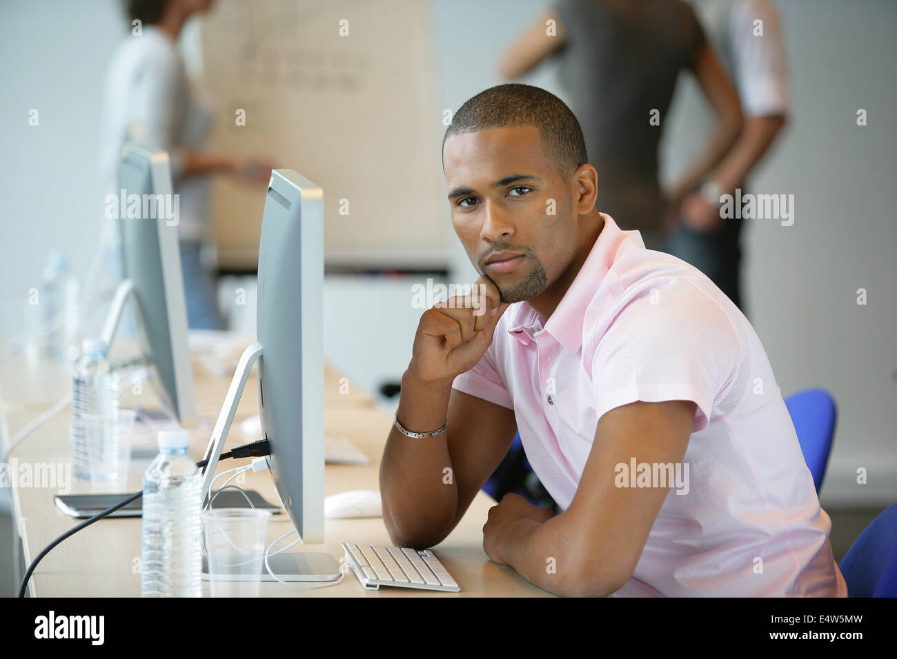 Casual man using a computer in an office Stock Photo - Alamy
