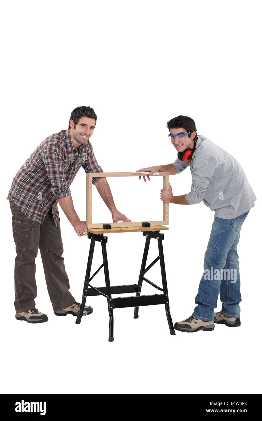 Tradesmen building a wooden frame Stock Photo - Alamy