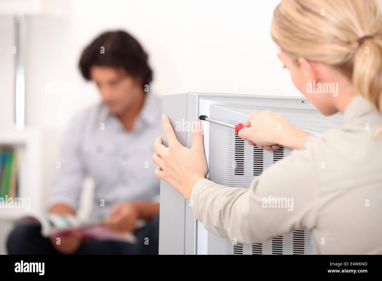 Woman taking the back off a television set Stock Photo - Alamy