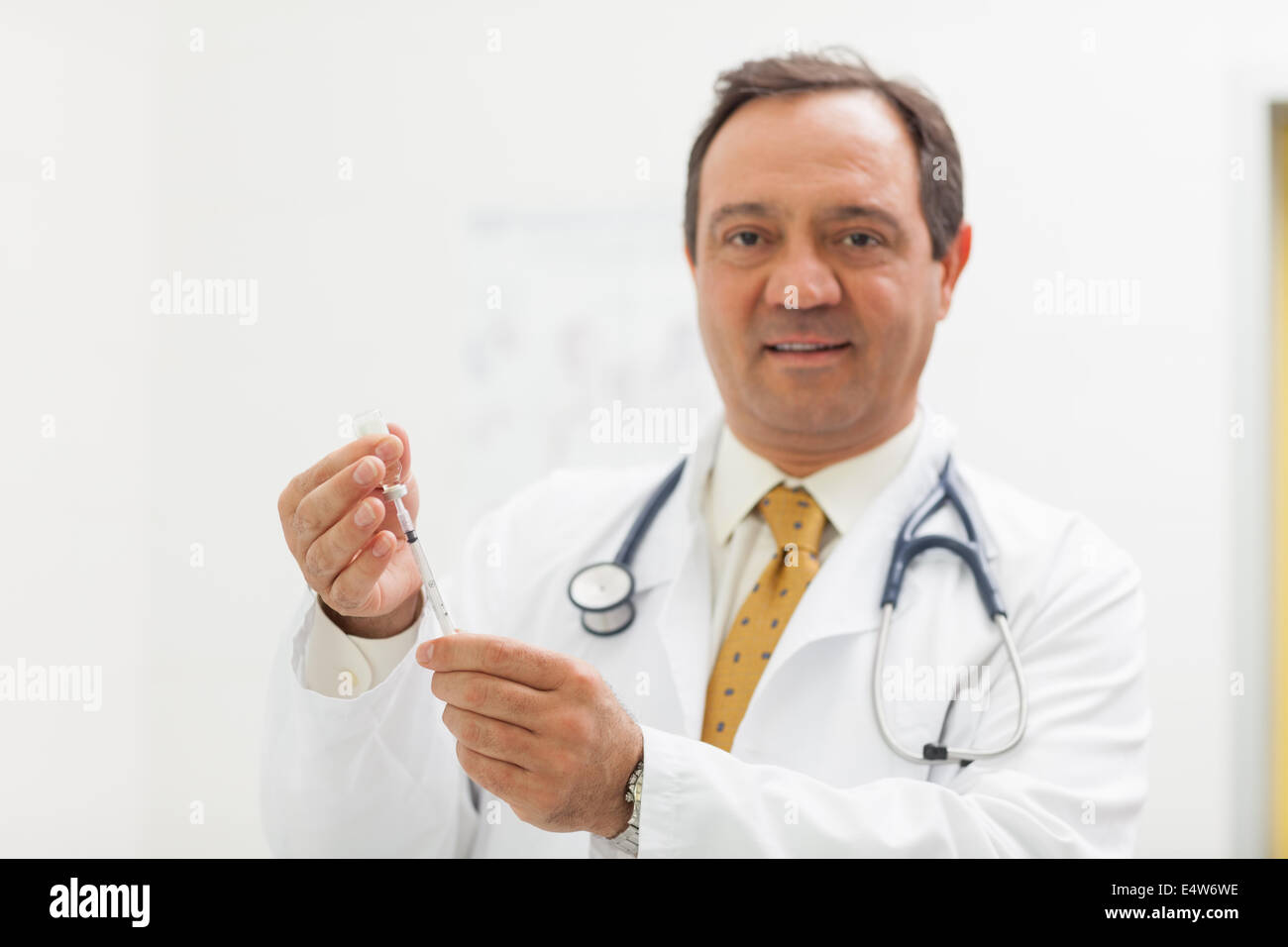 Smiling doctor preparing a syringe Stock Photo - Alamy