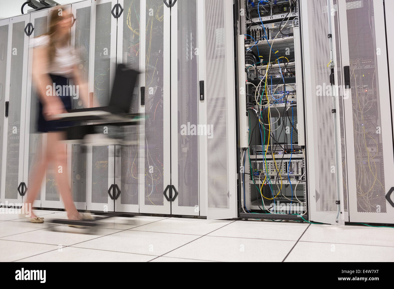 Woman pushing computer through data center Stock Photo - Alamy