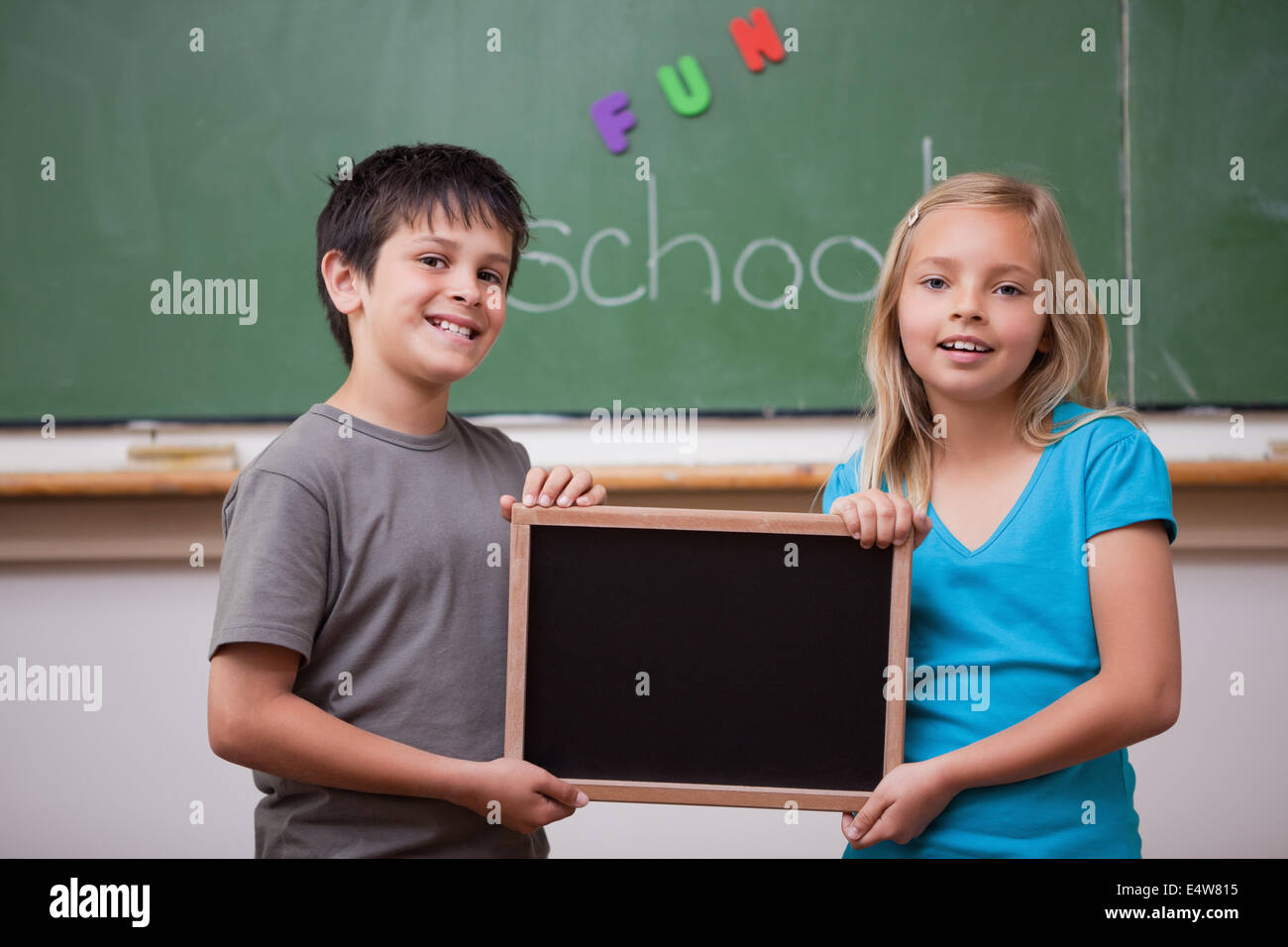 Smiling pupils holding a school slate Stock Photo - Alamy
