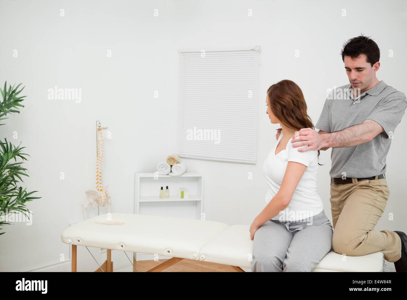 Osteopath looking at the back of a woman Stock Photo - Alamy