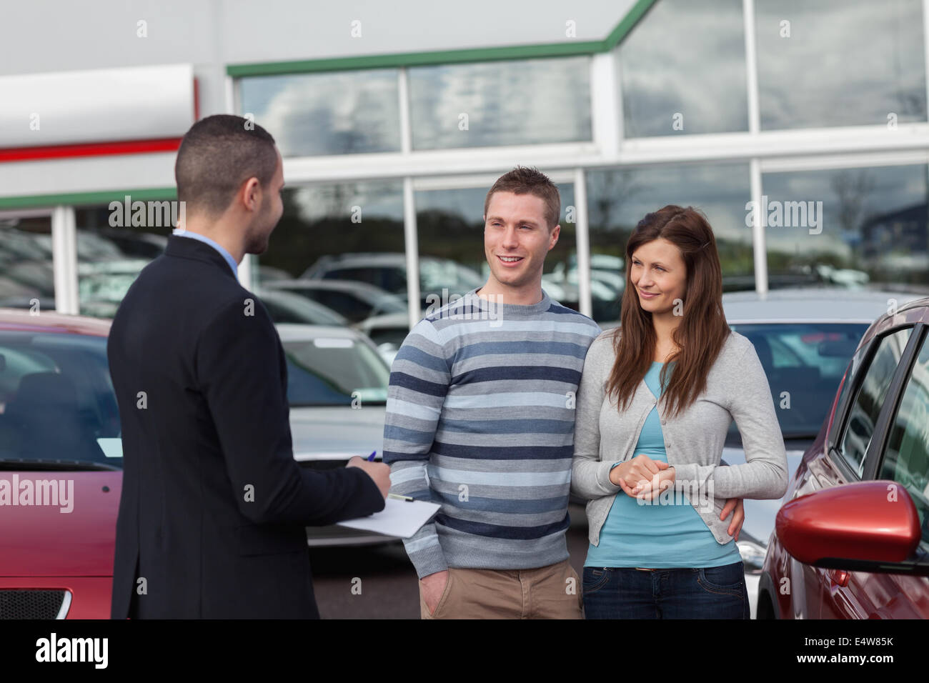 Salesman talking to a couple Stock Photo - Alamy