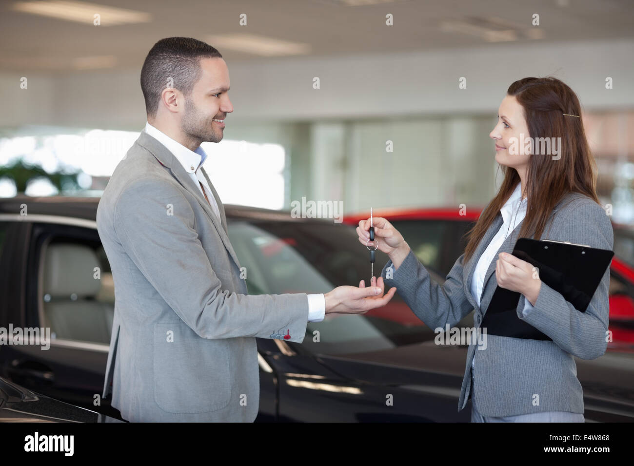Woman giving car keys to a client Stock Photo - Alamy