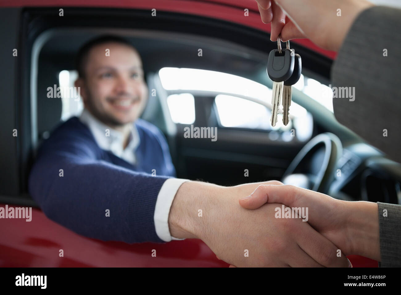 Woman giving car keys while shaking hand Stock Photo - Alamy