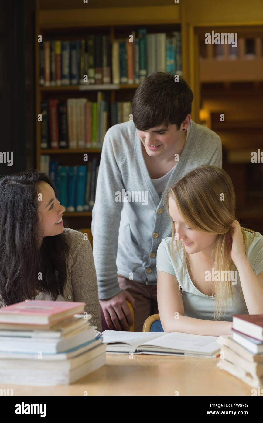 Student talking to classmates in the library Stock Photo - Alamy
