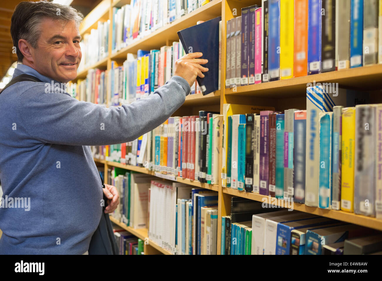 Man taking a book from shelf hi-res stock photography and images - Alamy