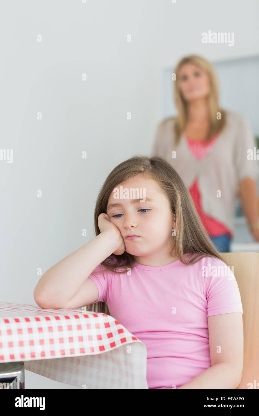 Frowning girl sitting table hi-res stock photography and images - Alamy
