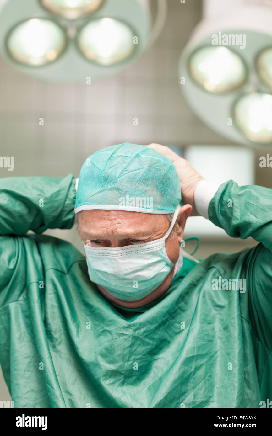 Surgeon putting on a face mask on his head Stock Photo - Alamy
