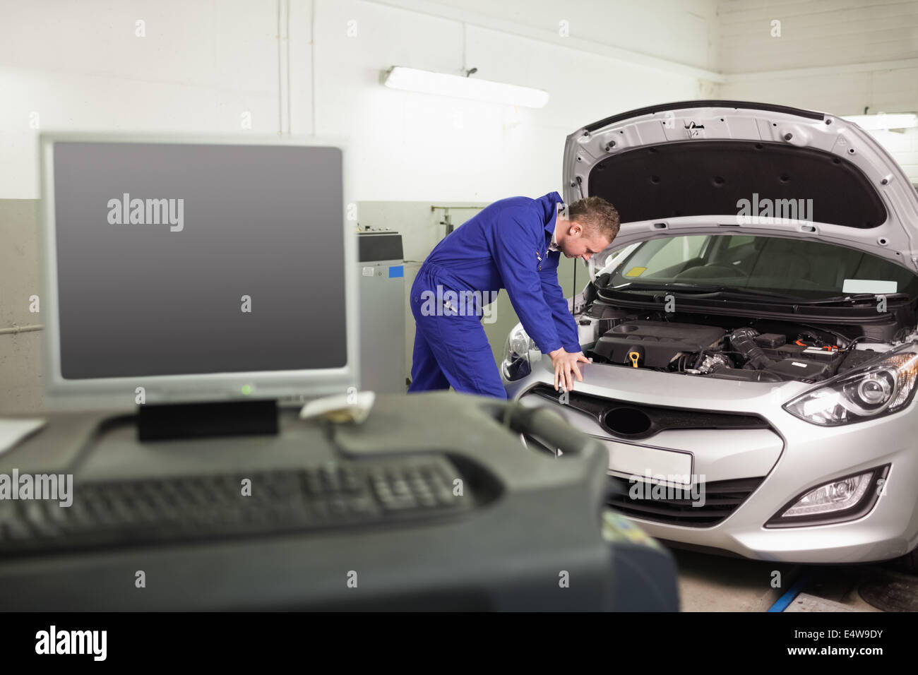 Mechanic examining a car engine Stock Photo - Alamy