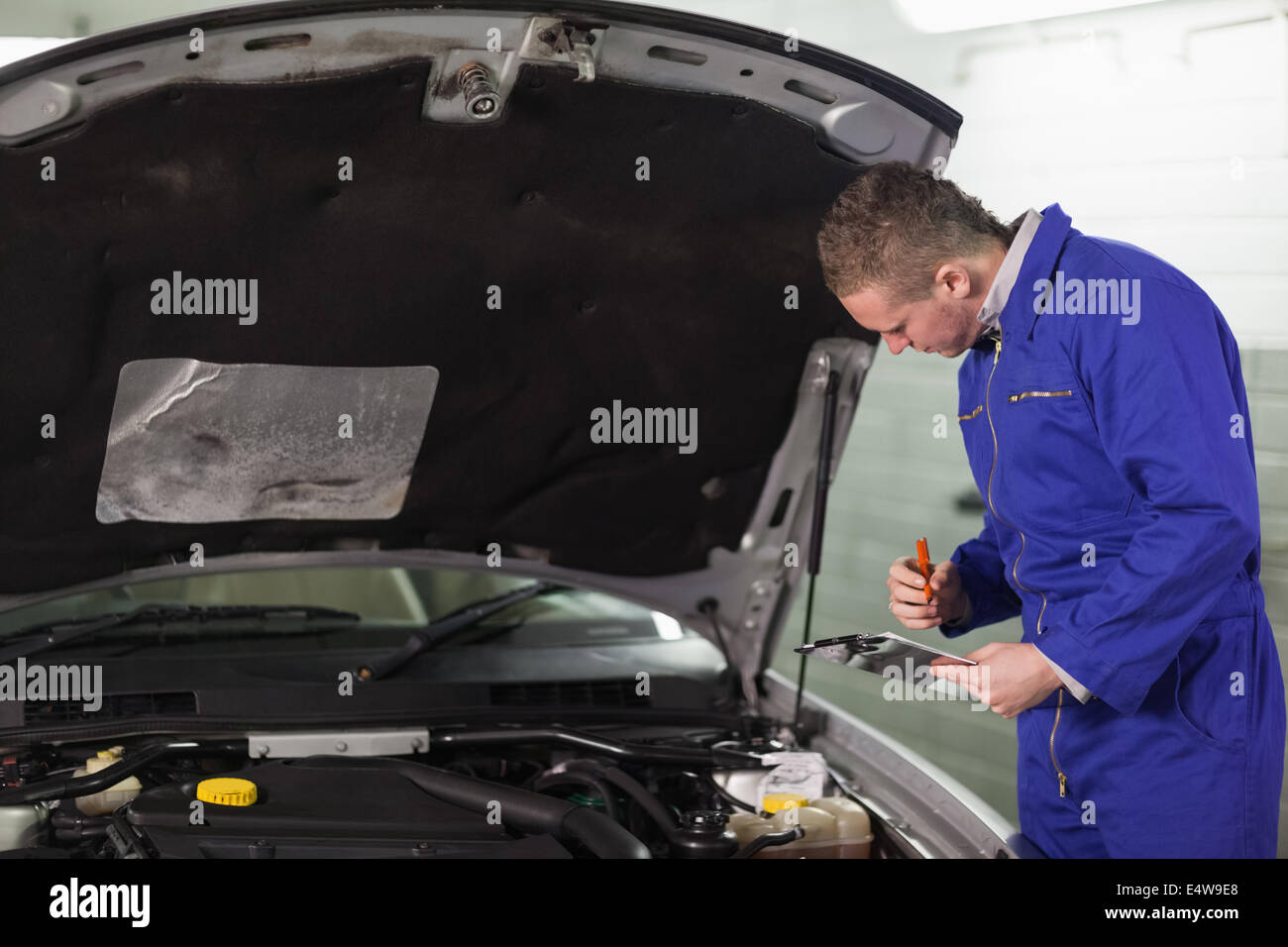 Mechanic holding a clipboard Stock Photo - Alamy