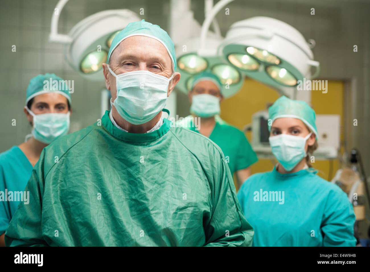 Smiling surgeon posing with a team Stock Photo - Alamy