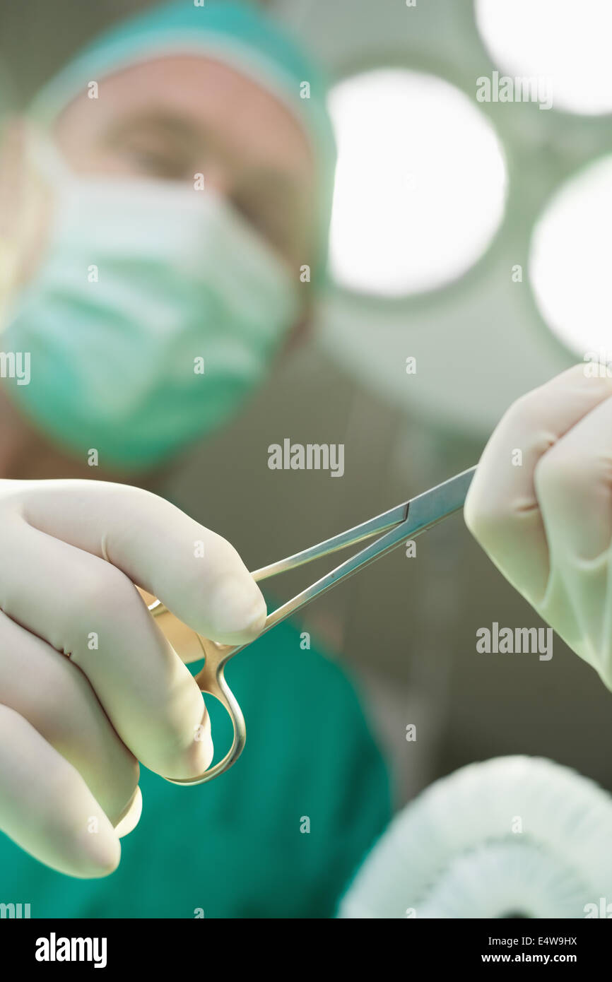 Surgeon holding scissors Stock Photo - Alamy