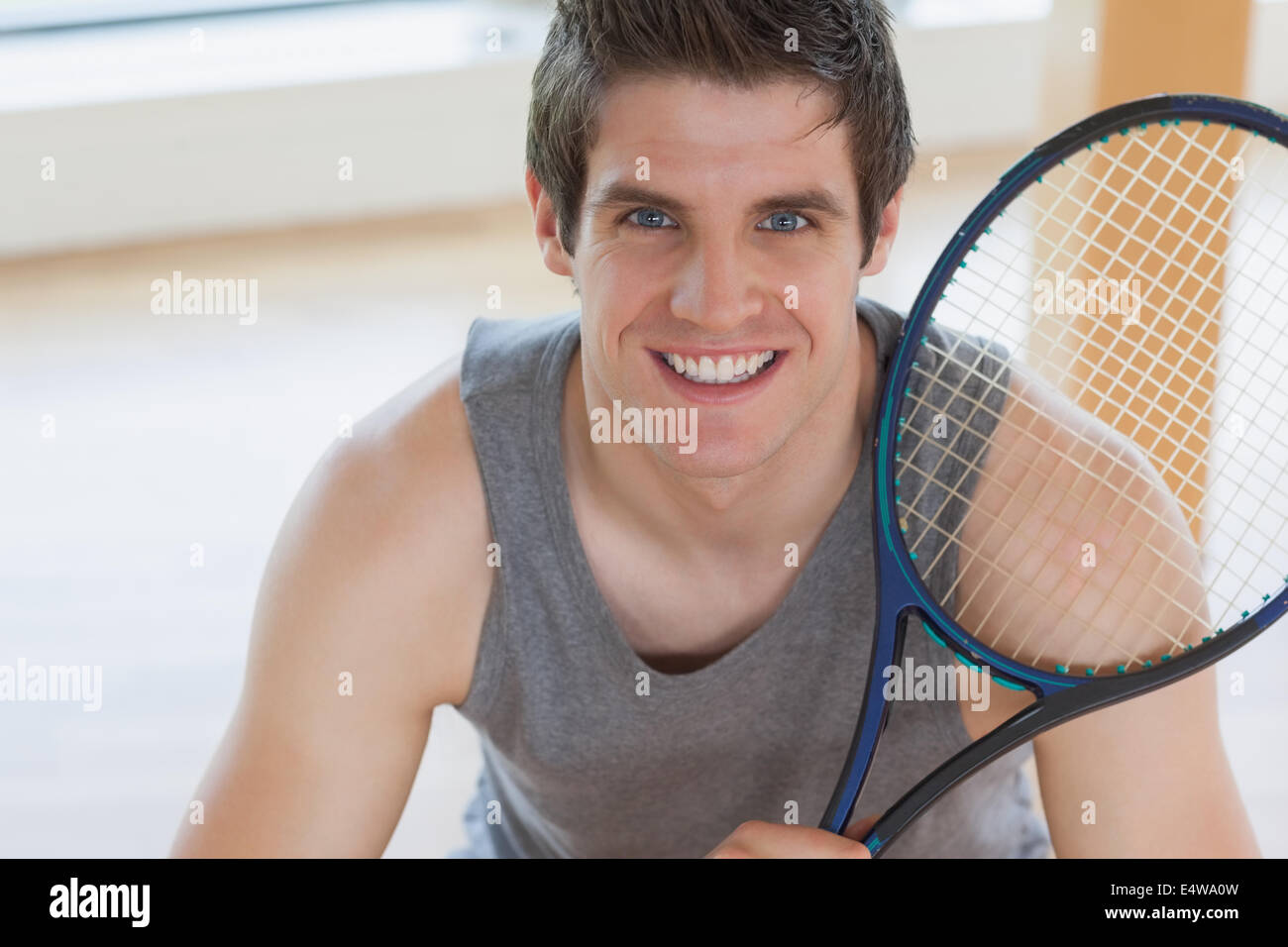Happy man holding a tennis racket Stock Photo - Alamy