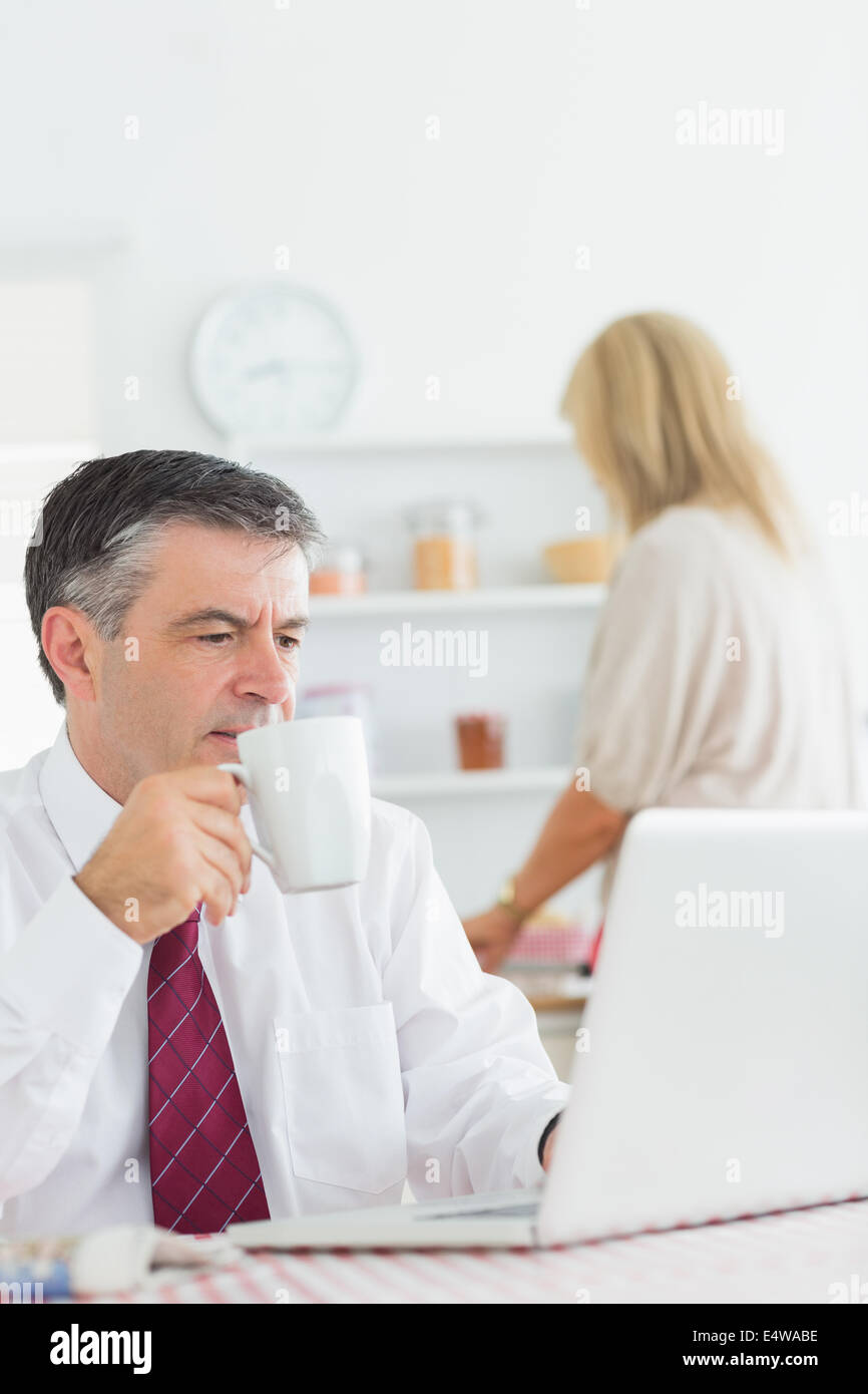 Man drinking coffee while checking laptop Stock Photo - Alamy Man drinking coffee while checking laptop Stock Photo - Alamy