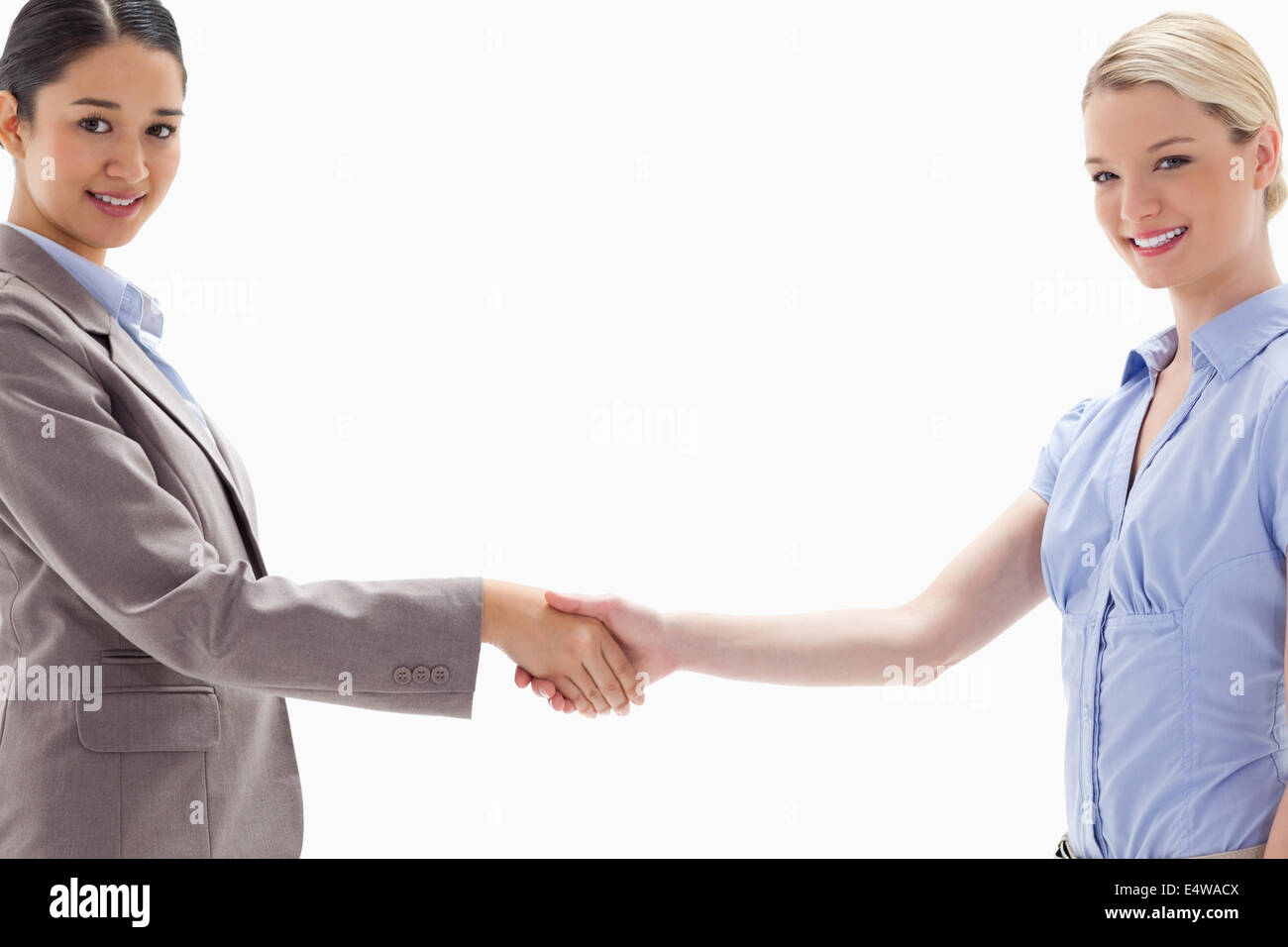 Close-up of smiling women shaking hands Stock Photo - Alamy