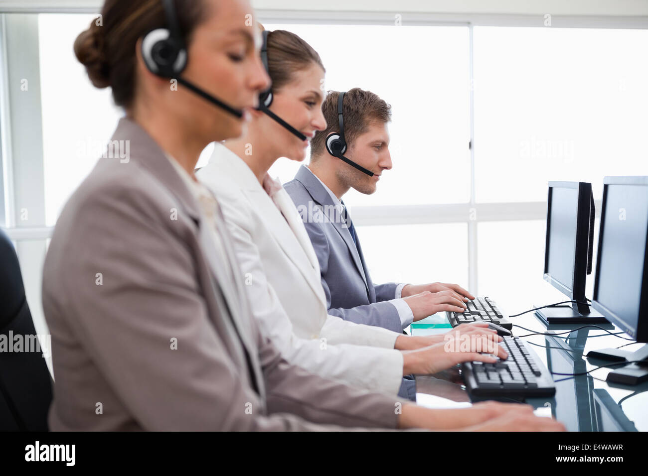 Side view of customer service assistants Stock Photo - Alamy