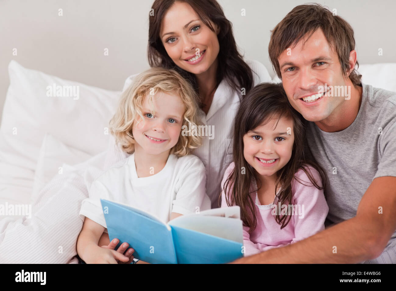 Happy family reading a book Stock Photo - Alamy