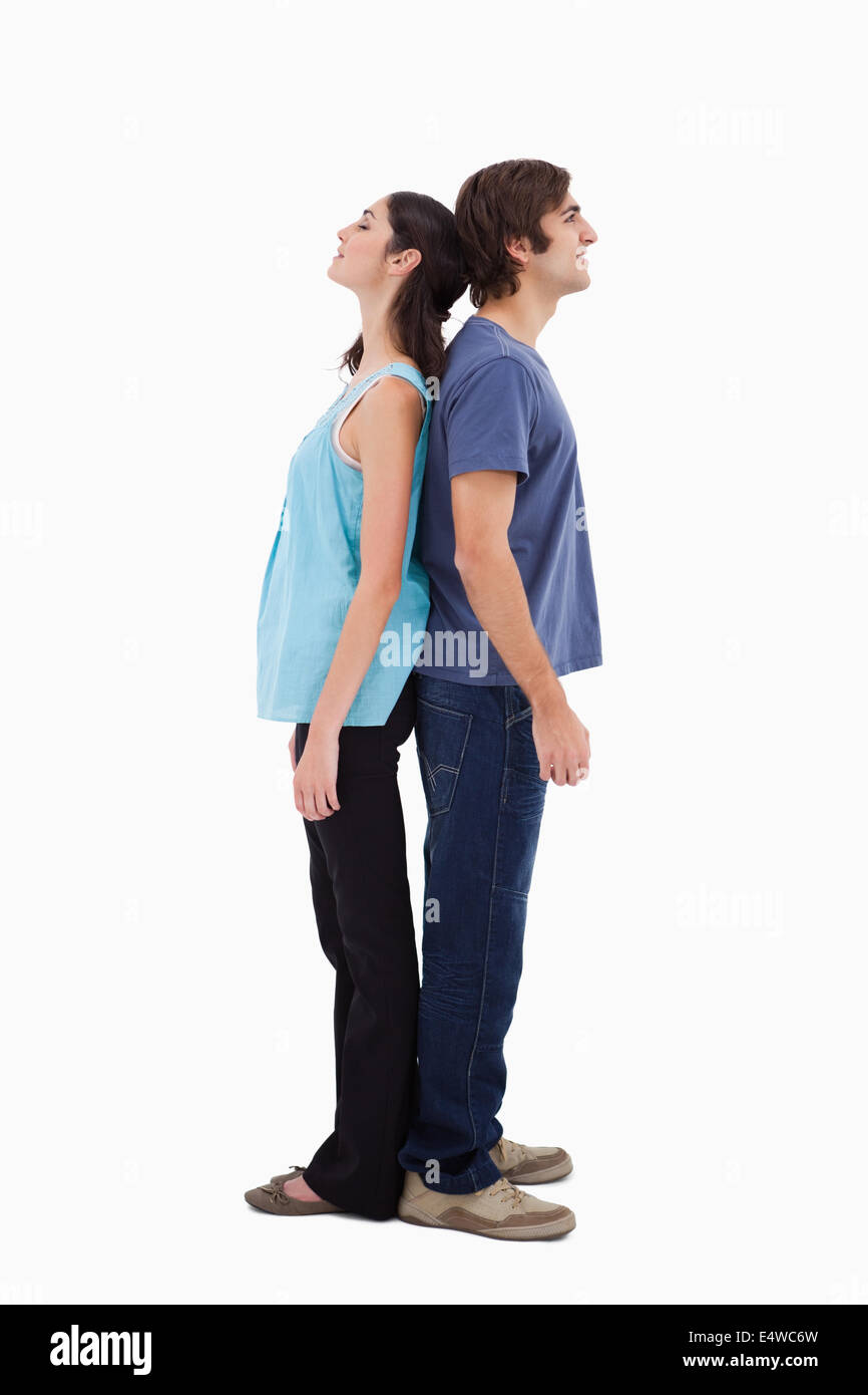 Portrait of a couple standing back to back Stock Photo - Alamy