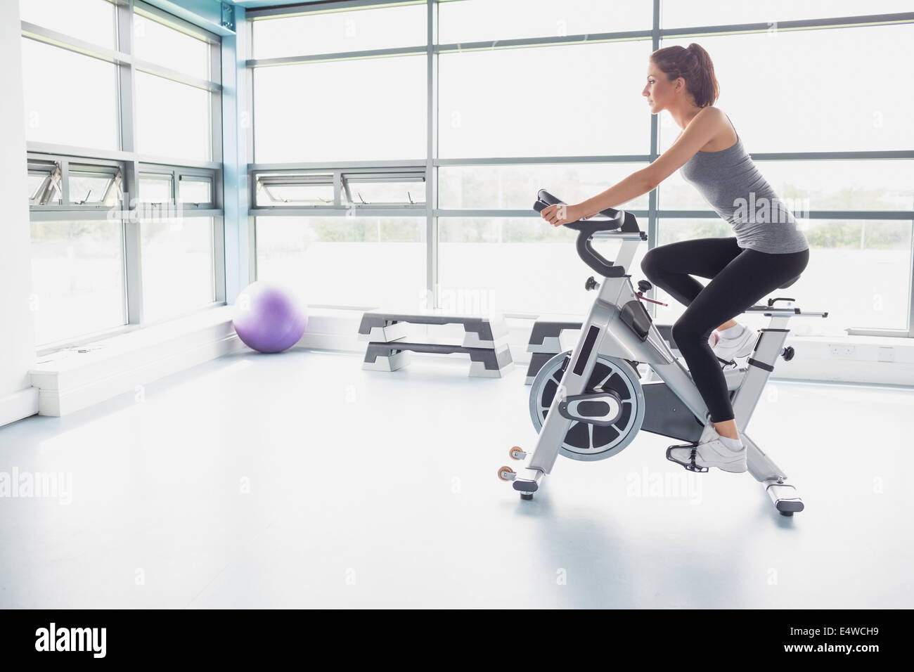 Woman riding an exercise bike Stock Photo - Alamy
