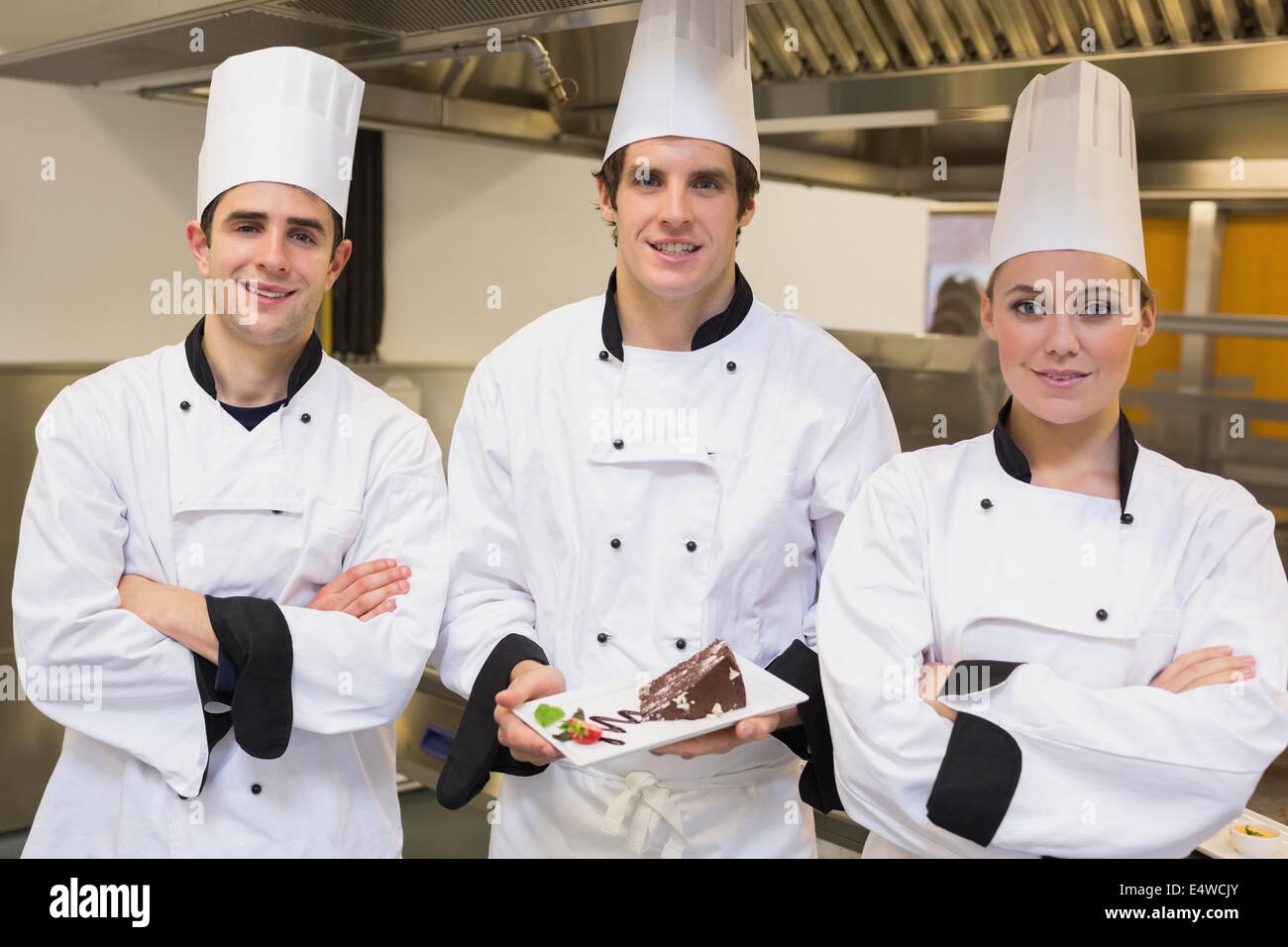 Three Chef's presenting a cake Stock Photo - Alamy