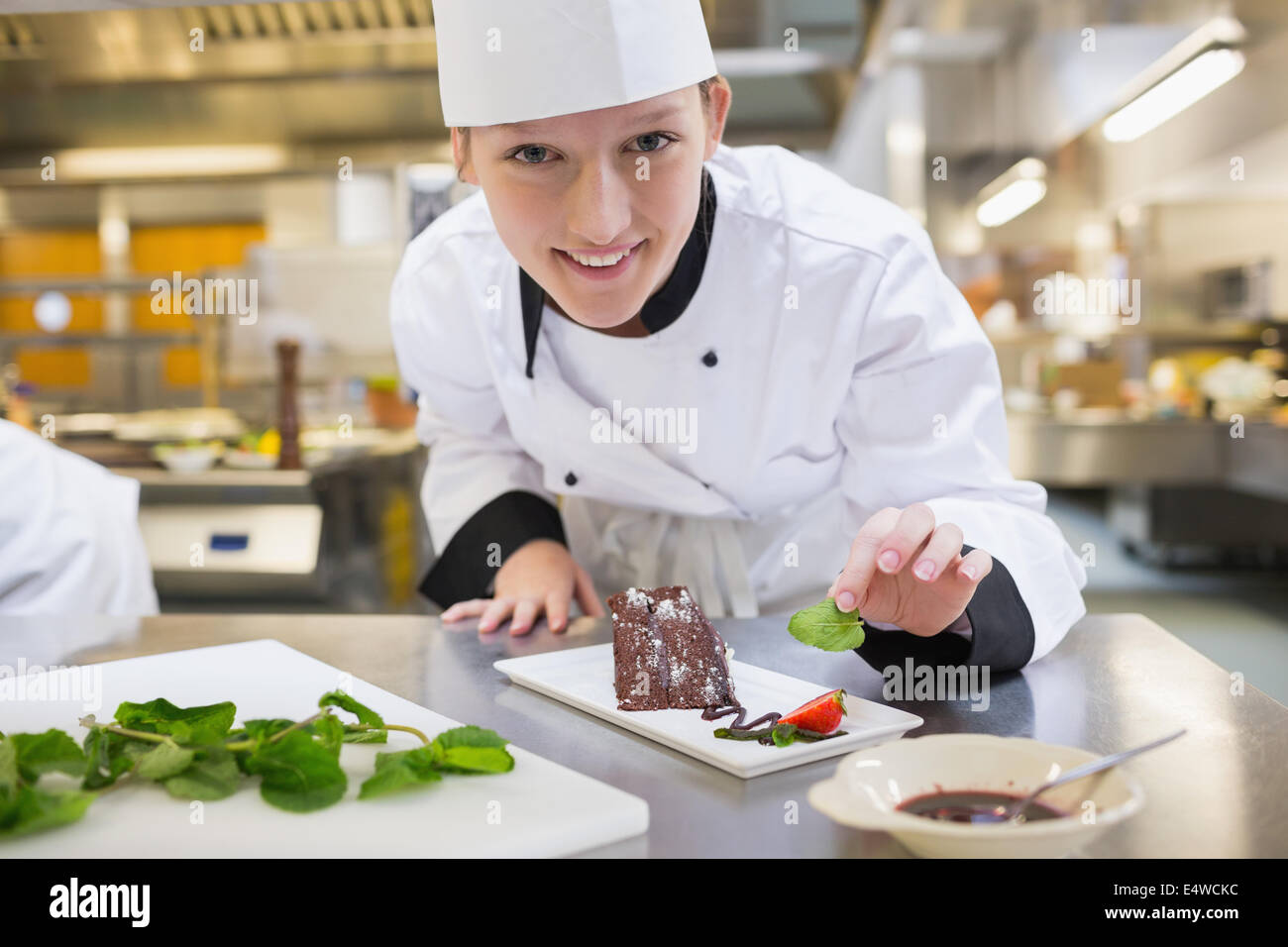 Smiling chef putting mint with her dessert Stock Photo - Alamy