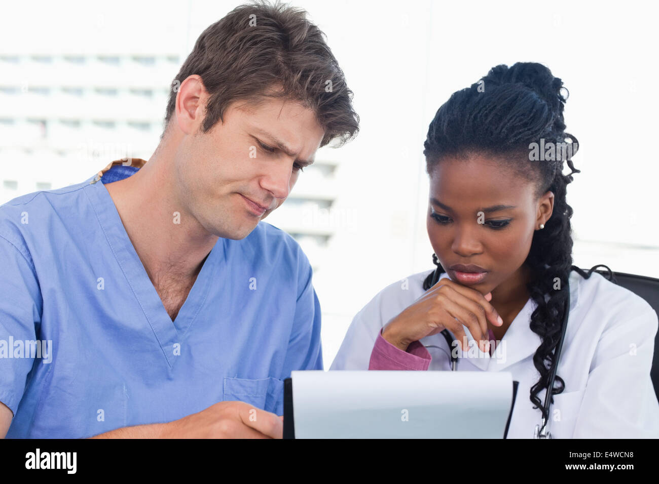Doctors looking at a document Stock Photo - Alamy