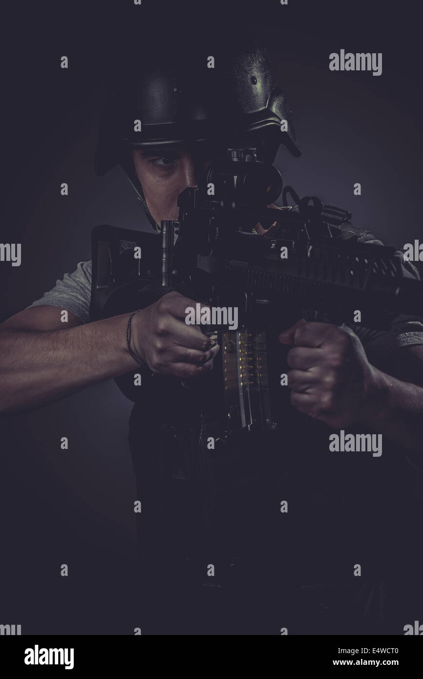 Riot, paintball sport player wearing protective helmet aiming pistol ...