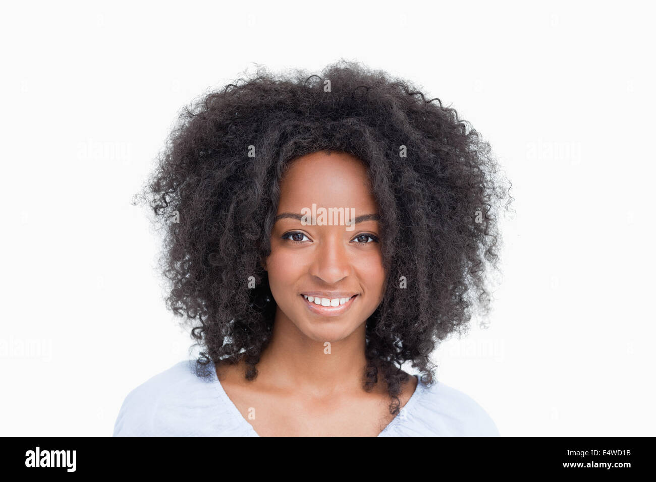 Young woman with curly hair standing upright Stock Photo - Alamy