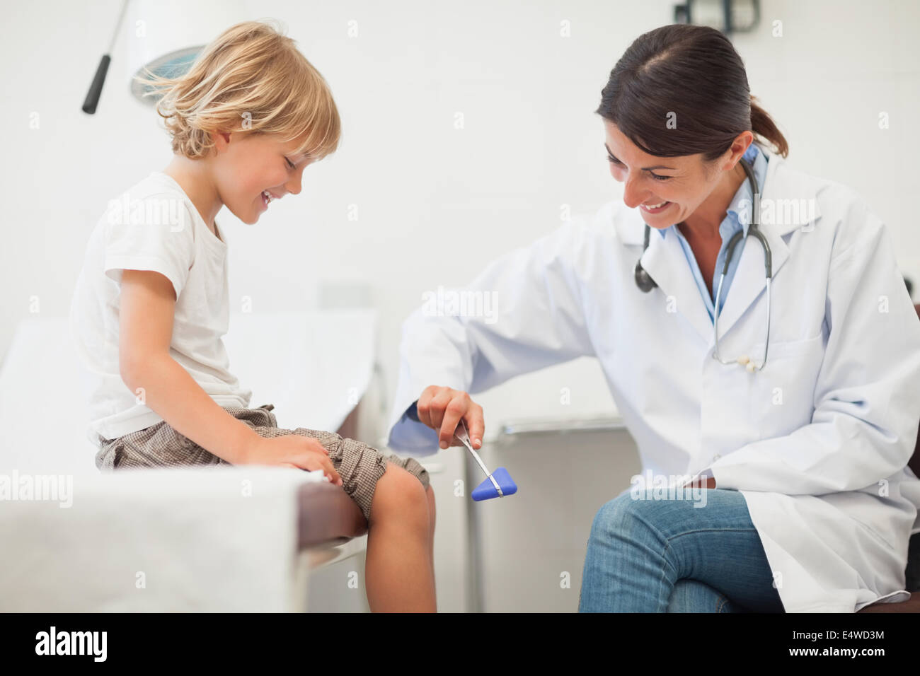 Doctor testing reaction of a child leg Stock Photo - Alamy