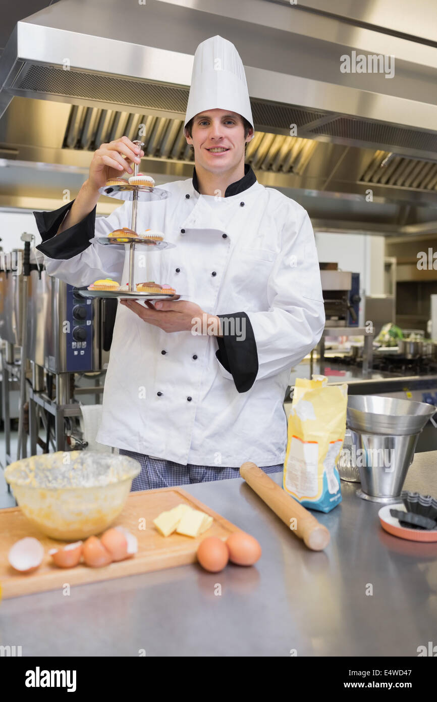 Pastry chef presenting tiered cake tray Stock Photo - Alamy