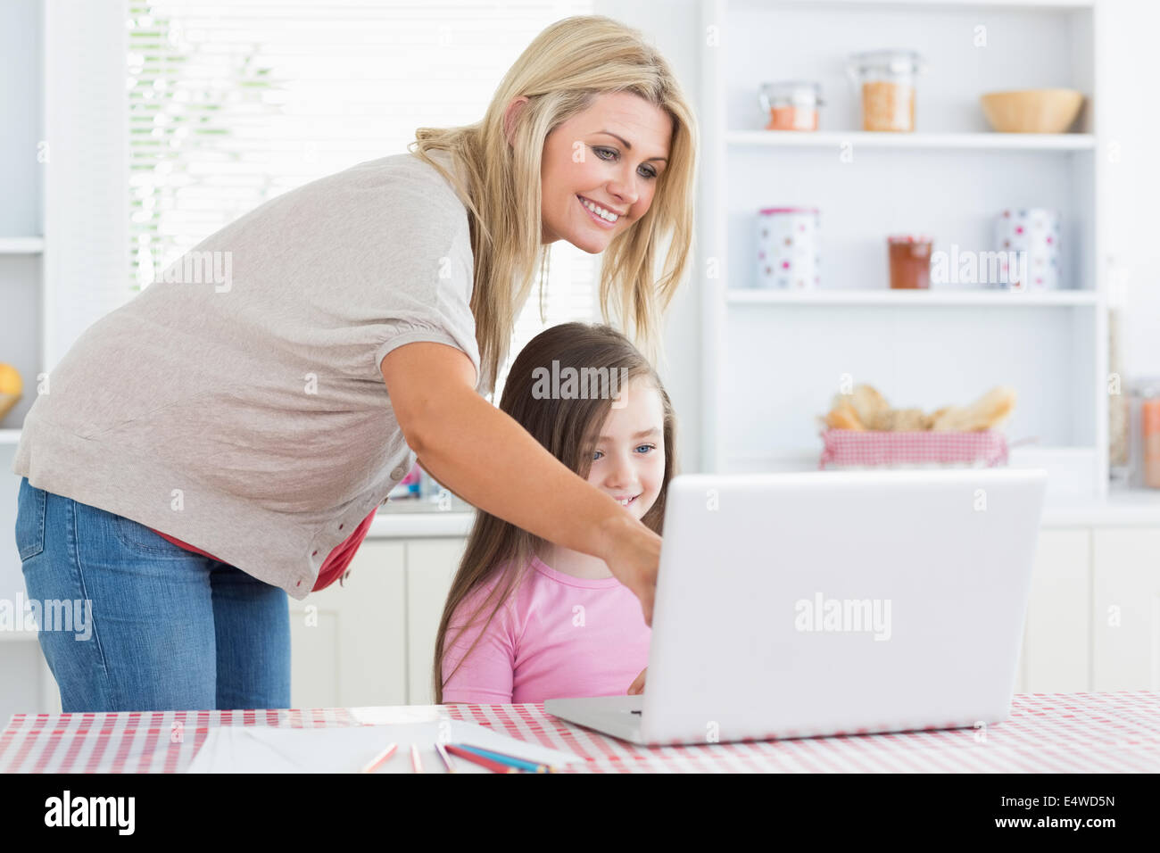 Mother pointing at laptop with daughter Stock Photo - Alamy