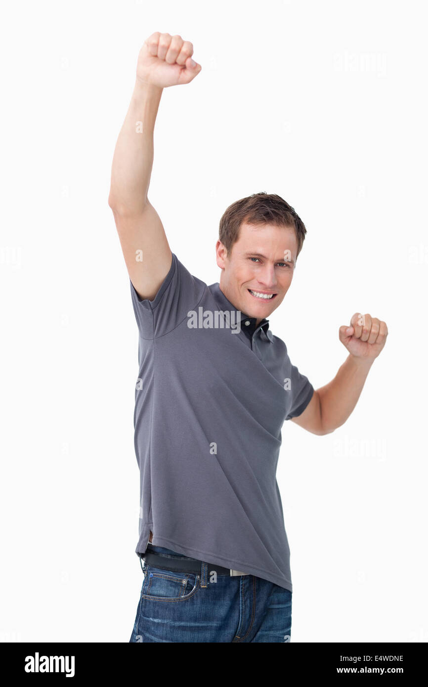 Victorious young man raising fist Stock Photo - Alamy