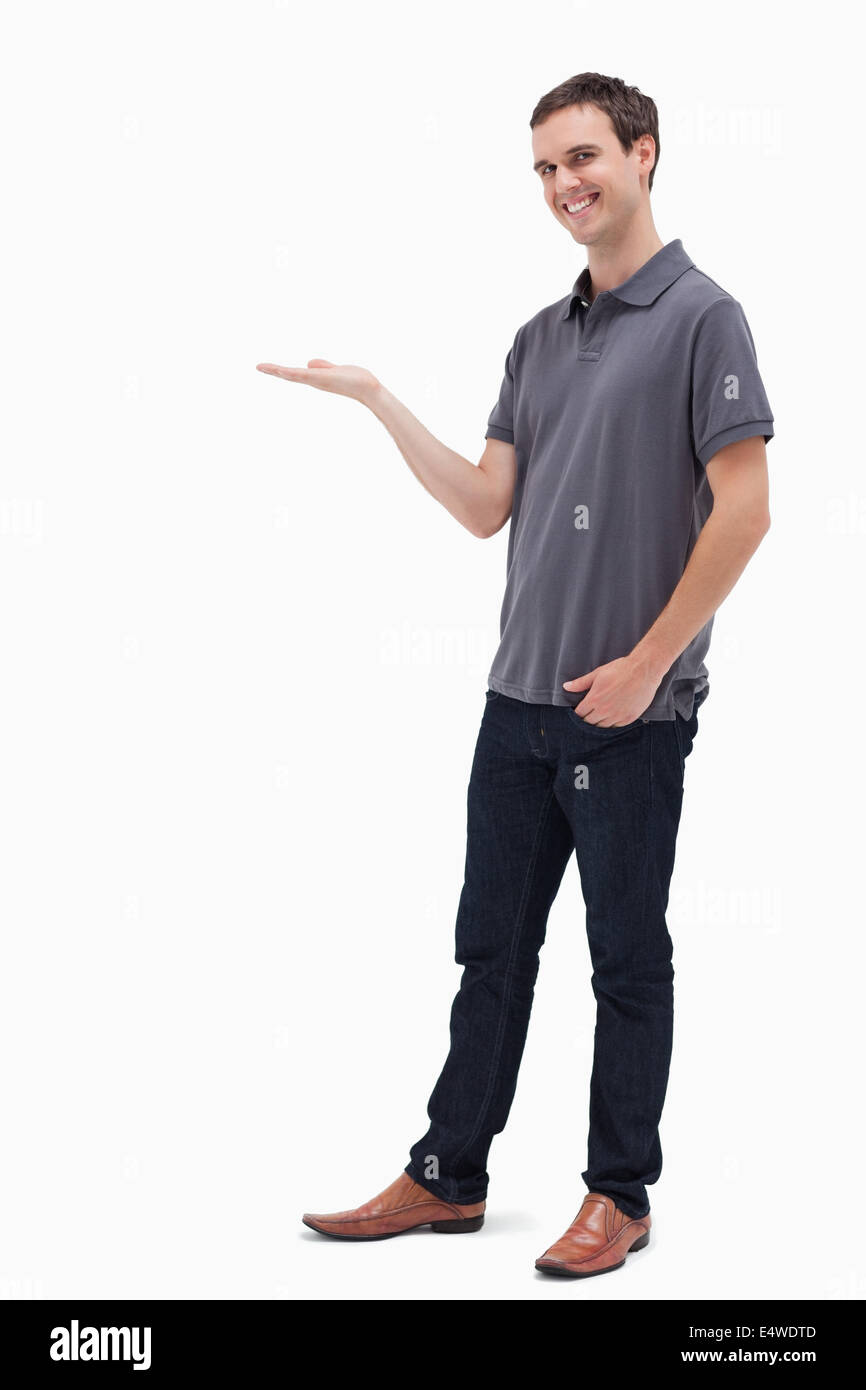 Happy man standing while presenting Stock Photo - Alamy