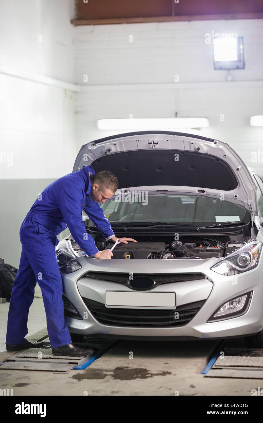 Mechanic looking at the car engine Stock Photo - Alamy