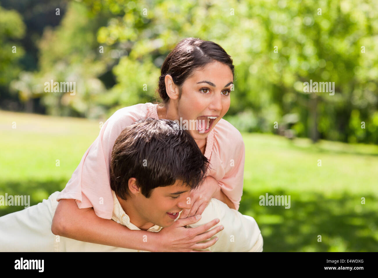 Woman getting a ride on her friends back Stock Photo - Alamy