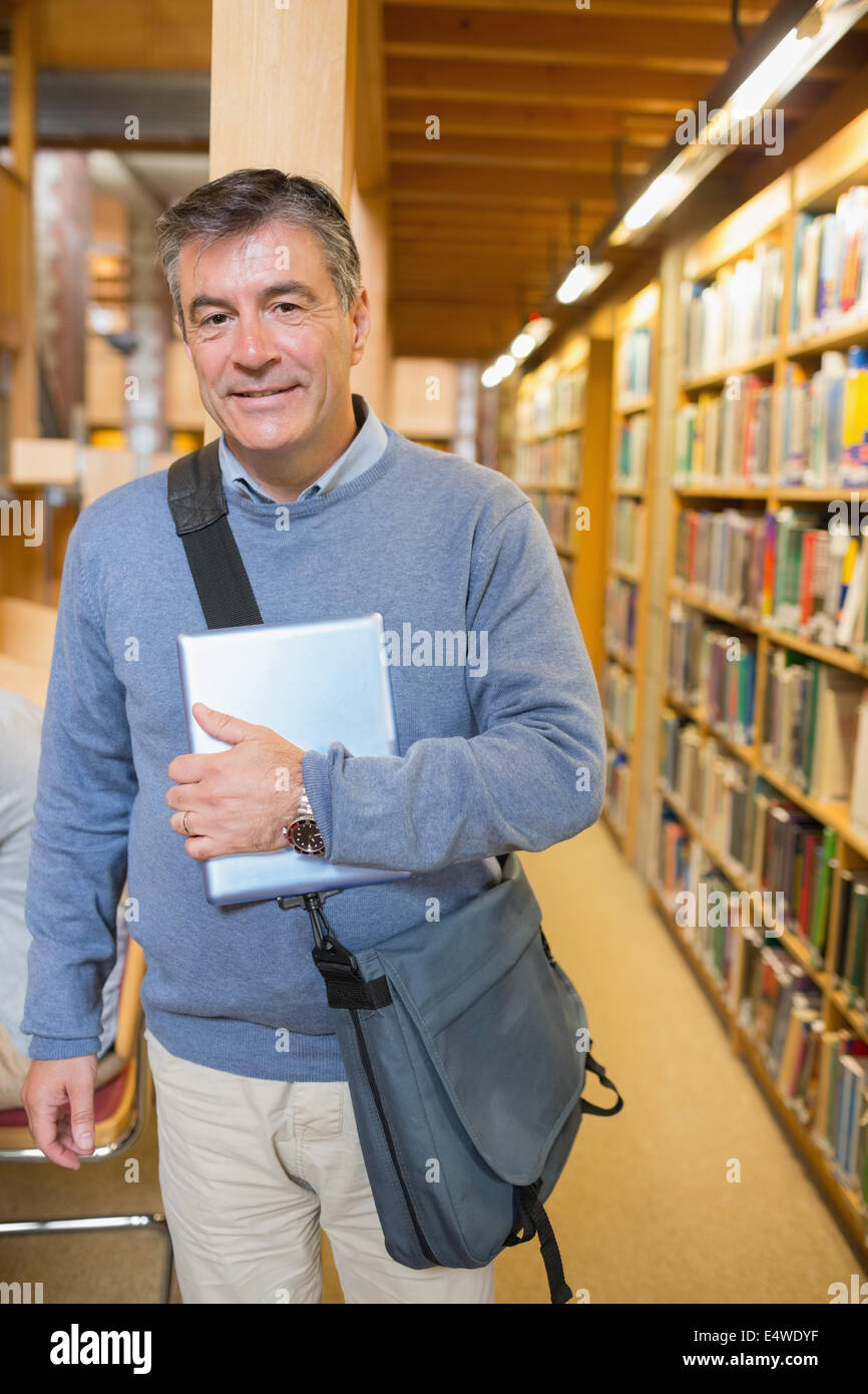 Man standing next to shelves in a library Stock Photo - Alamy