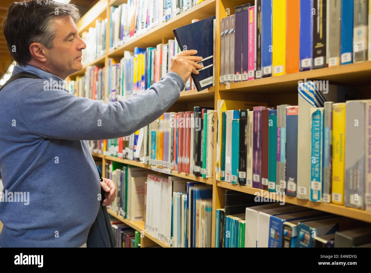 Man taking a book from shelf hi-res stock photography and images - Alamy