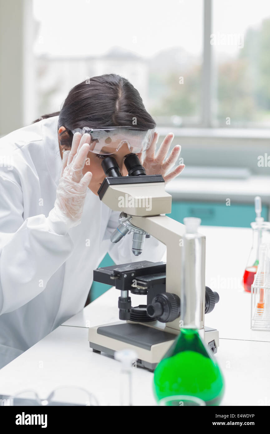 Woman looking through microscope Stock Photo - Alamy